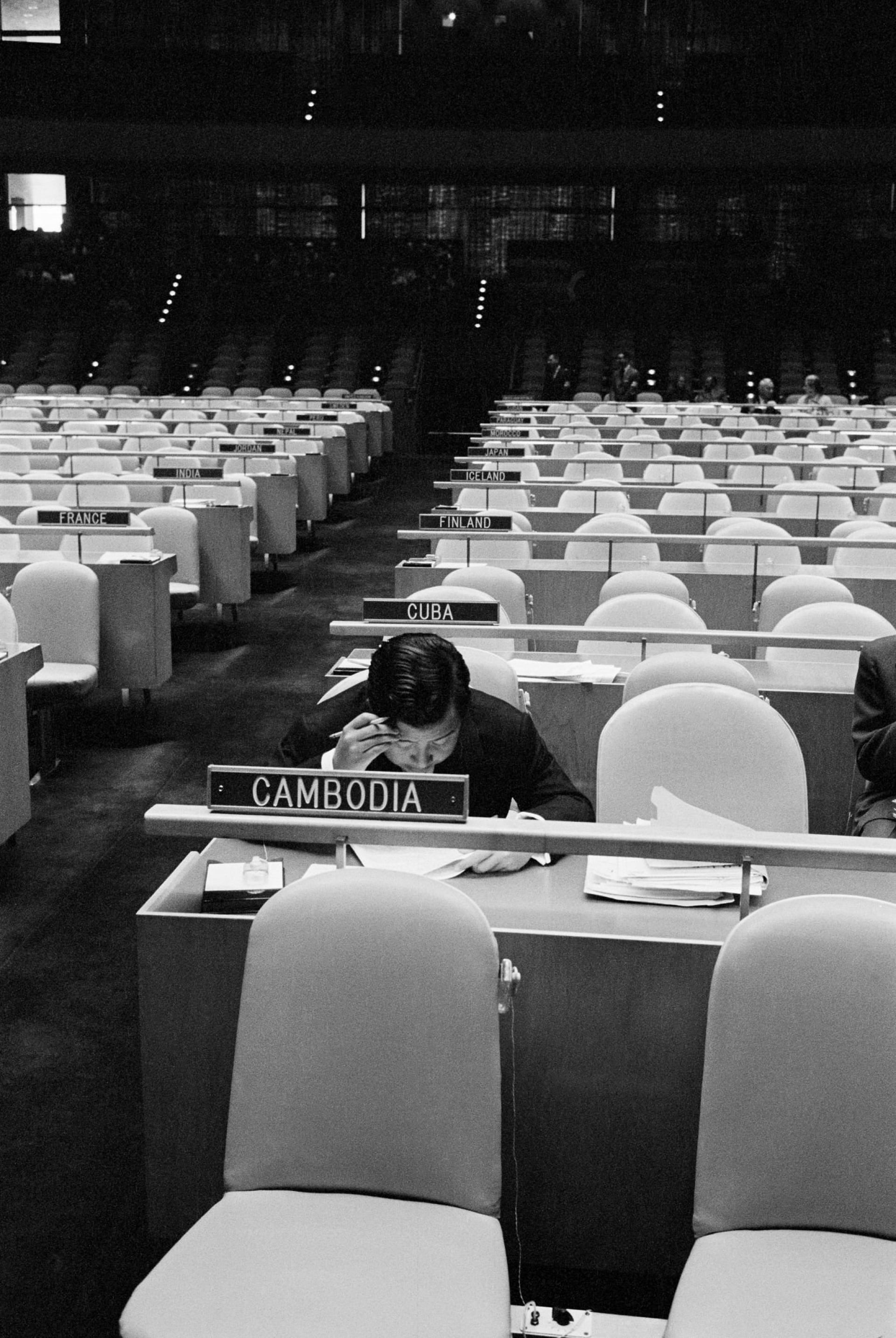 Prince Norodom Shihanouk, PM of Cambodia, reading in a sparsely ...