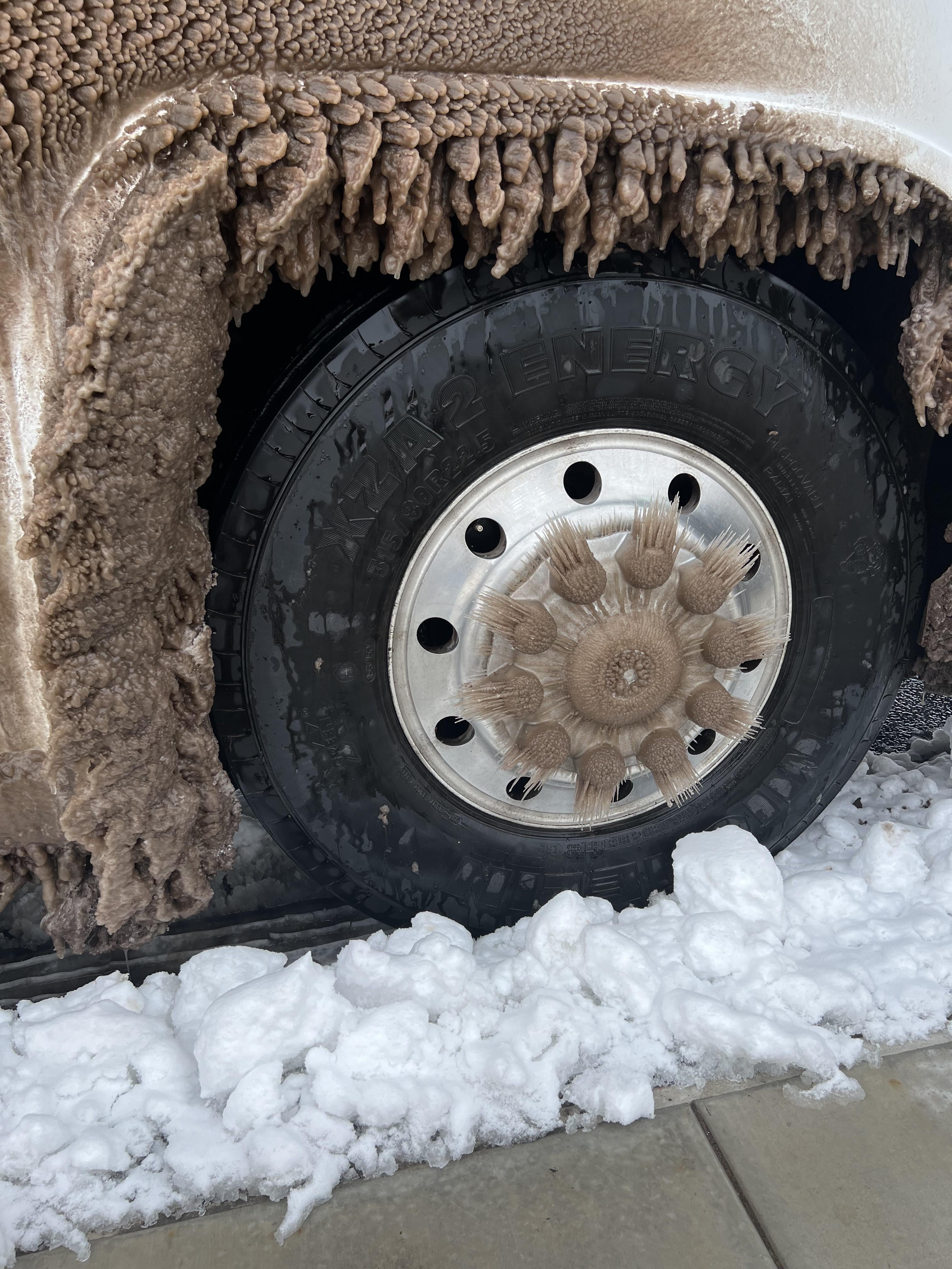 Ice formation on a bus tire during a huge snow storm. After several ...