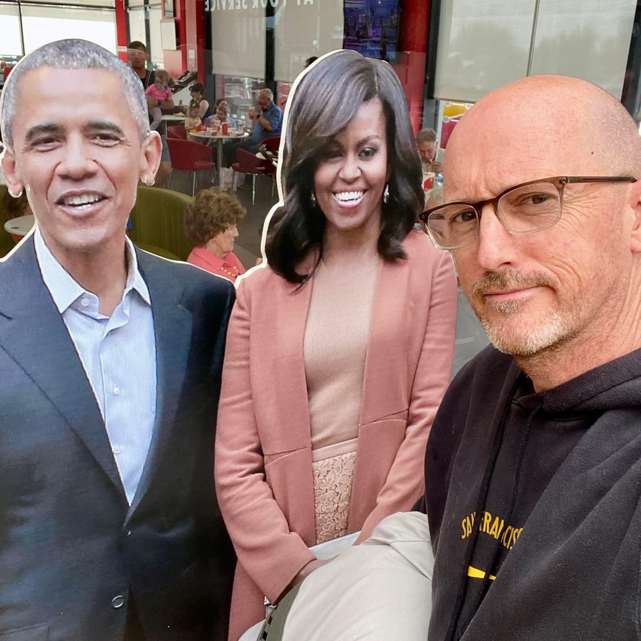 Standing with a large cut-out of Barack and Michelle Obama at a gas ...